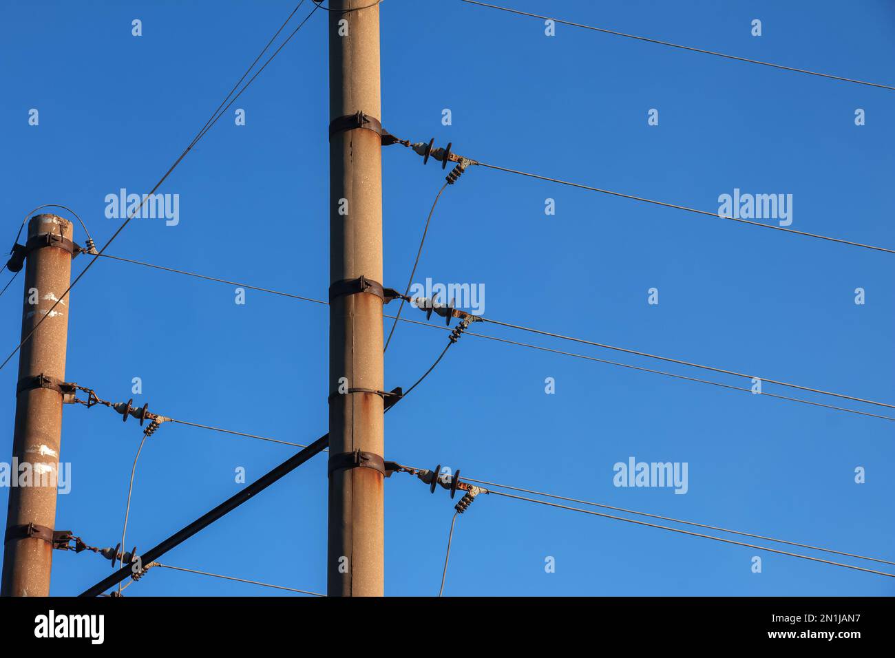 Electric pole with a linear wire against the blue sky close-up. Power ...