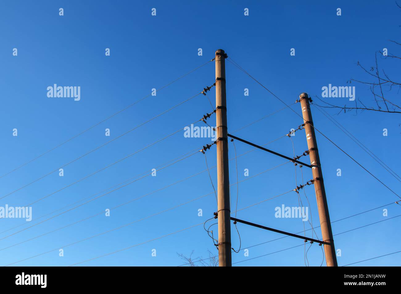 Electric pole with a linear wire against the blue sky close-up. Power ...