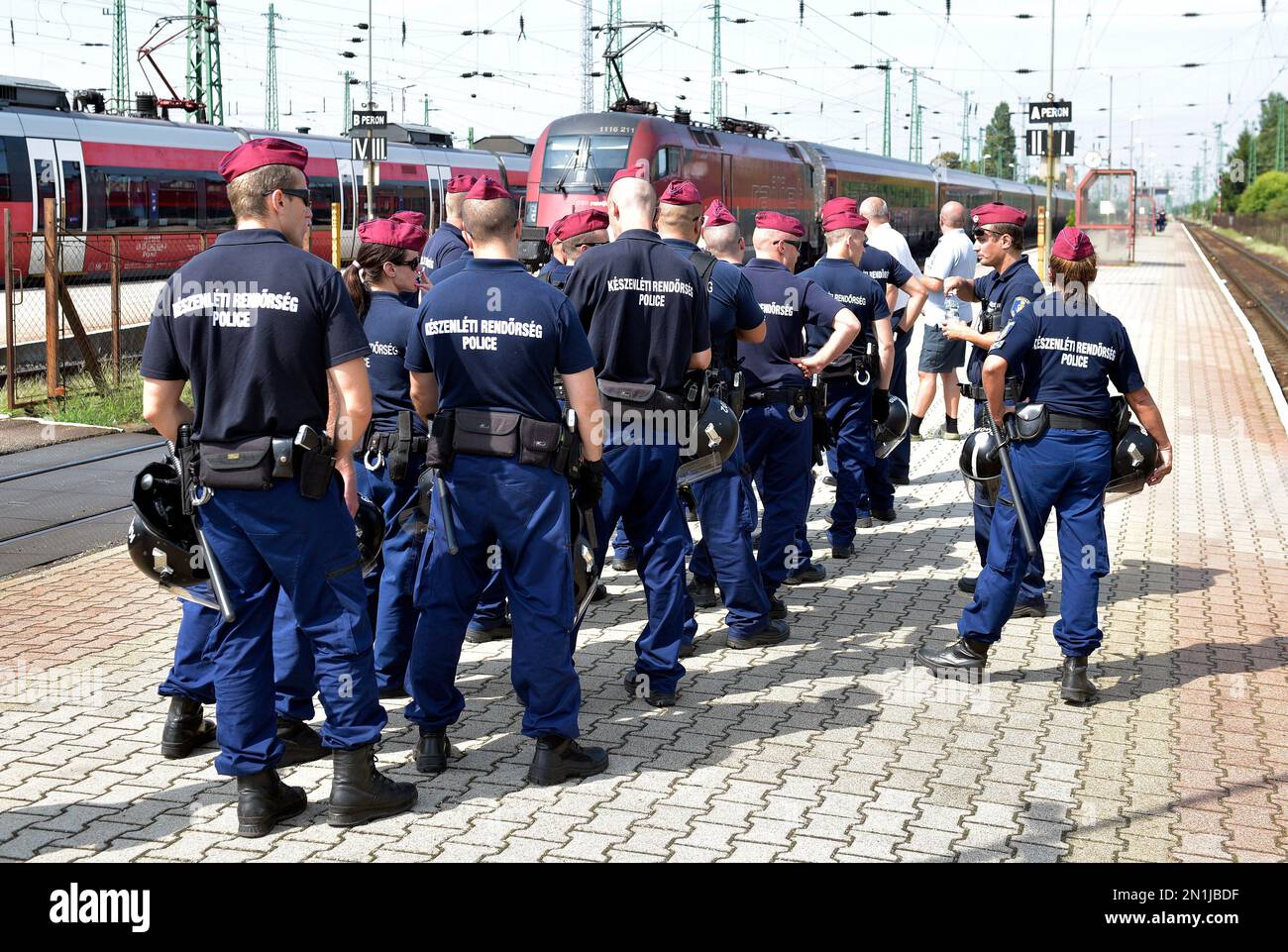 Hungarian police officers stand in front of a train at the railway ...