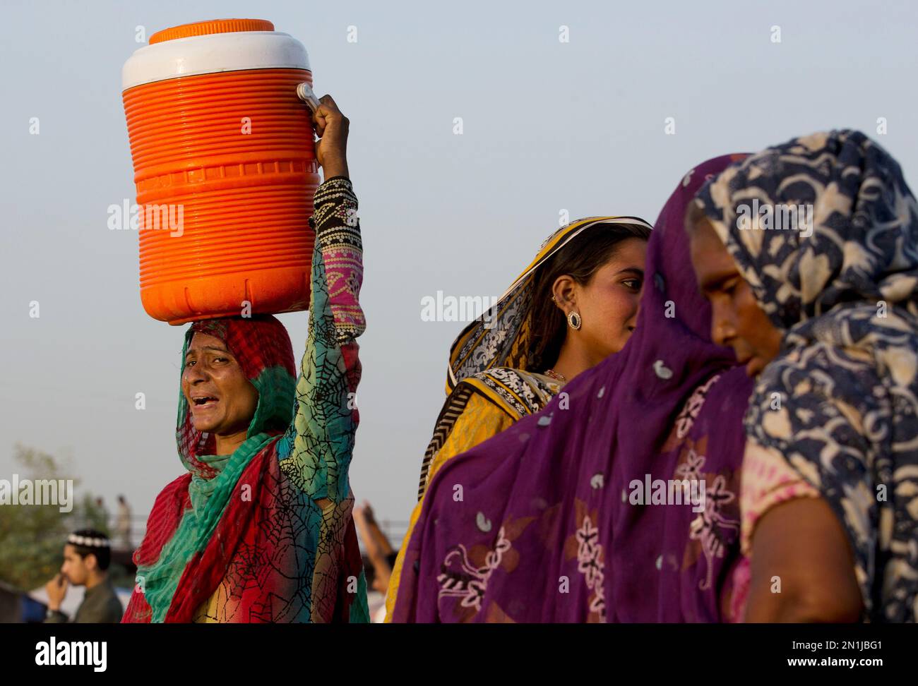 A Pakistani woman carries clean water for her home in Rawalpindi ...
