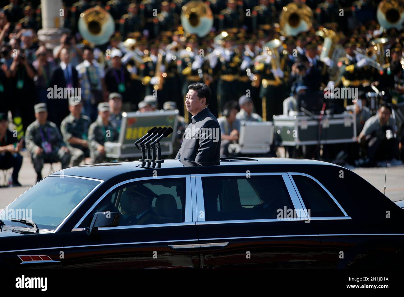 Chinese President Xi Jinping stands in a car to review the army during ...