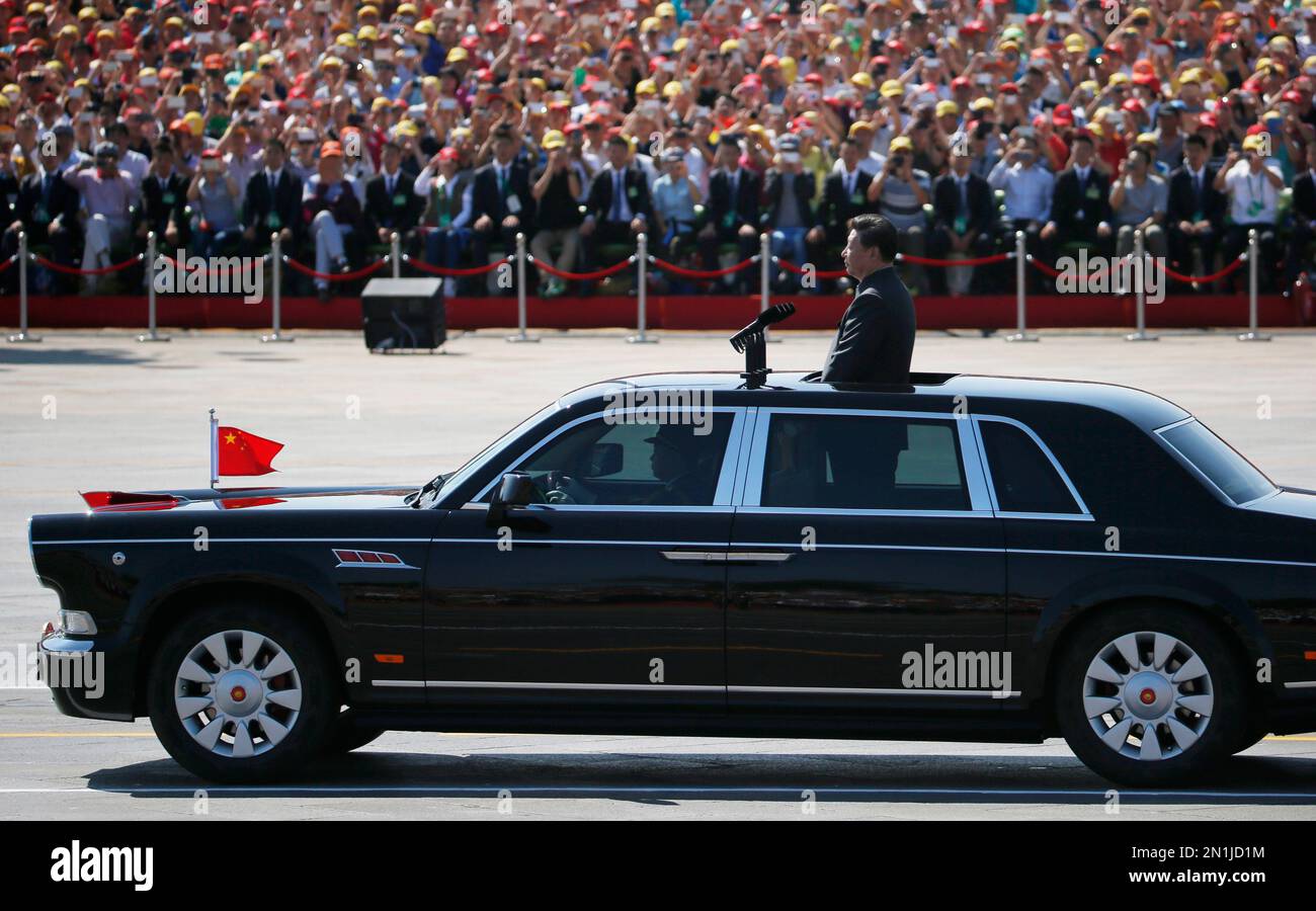 Chinese President Xi Jinping stands in a car to review the army during ...