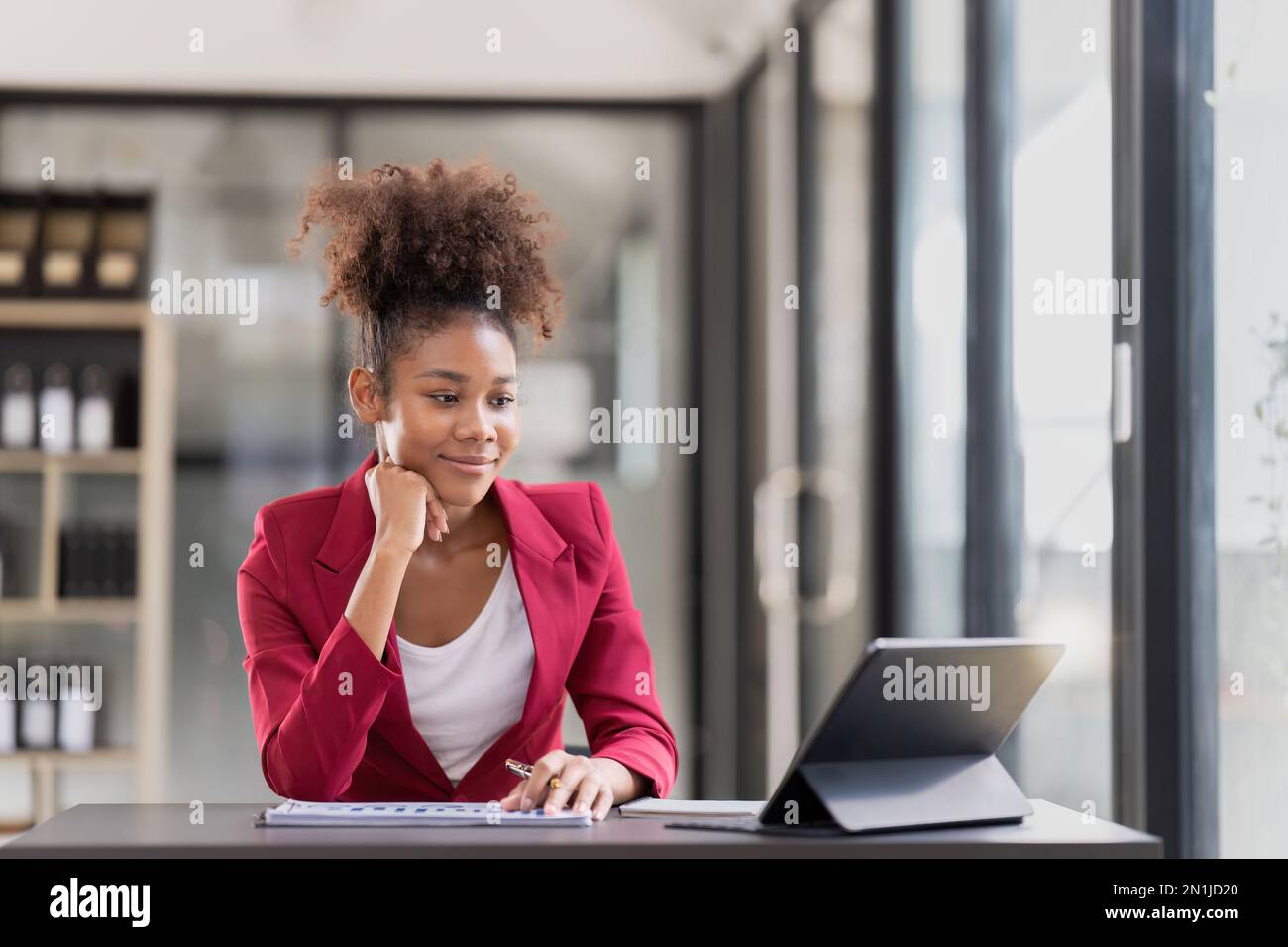 Female office worker working on a laptop in an office Stock Photo - Alamy
