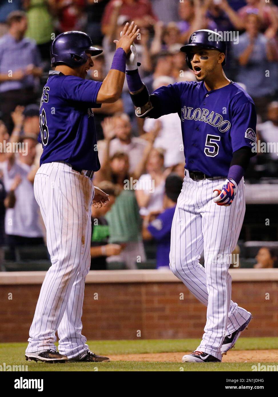 Colorado Rockies' Carlos Gonzalez (5) high fives teammate Cristhian ...