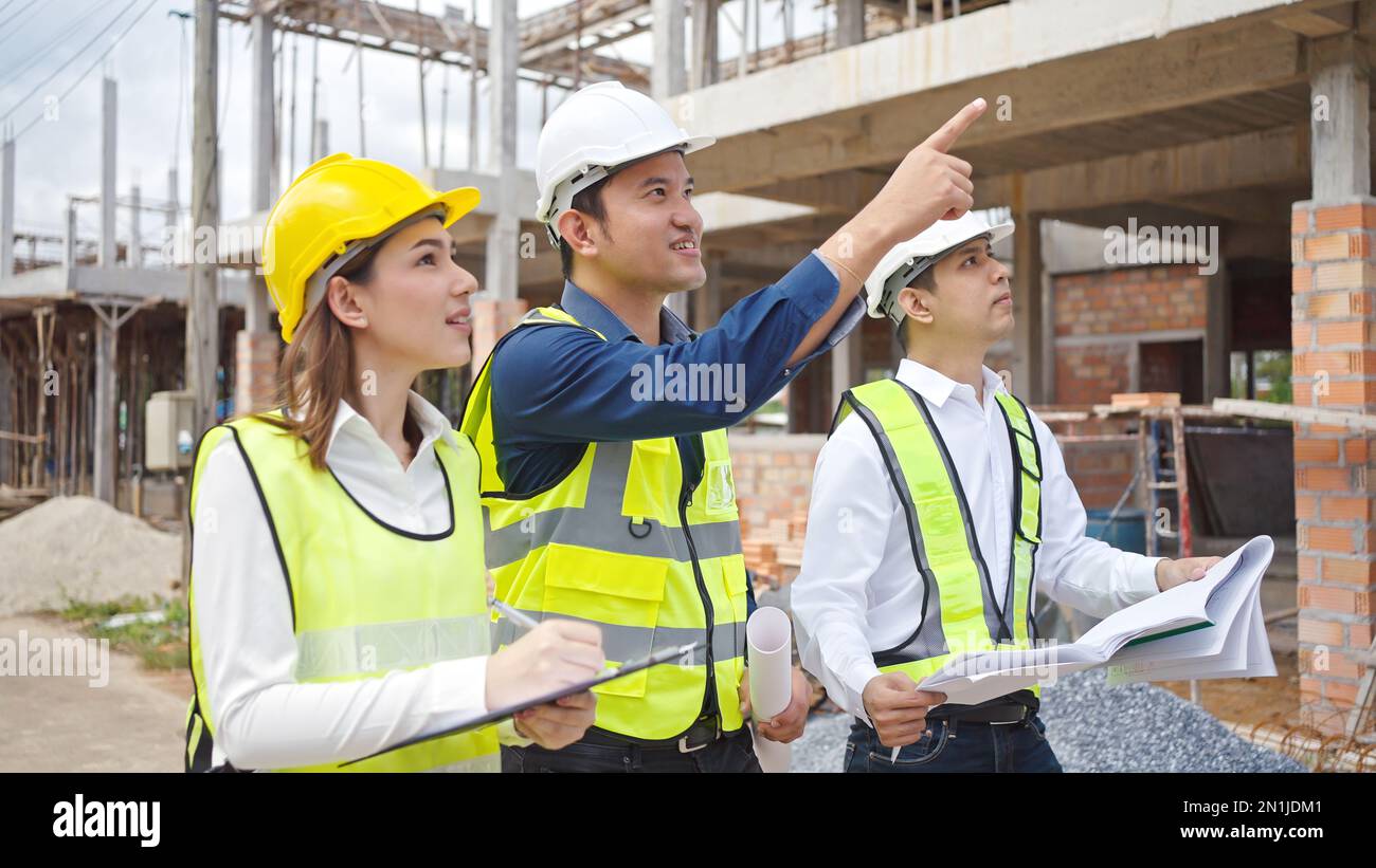 Asian Architector and engineers team with draft plan of building ...