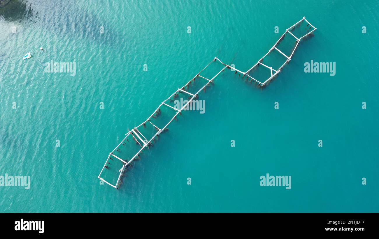 An aerial shot of mussels farms in the blue calm waters of the ocean ...
