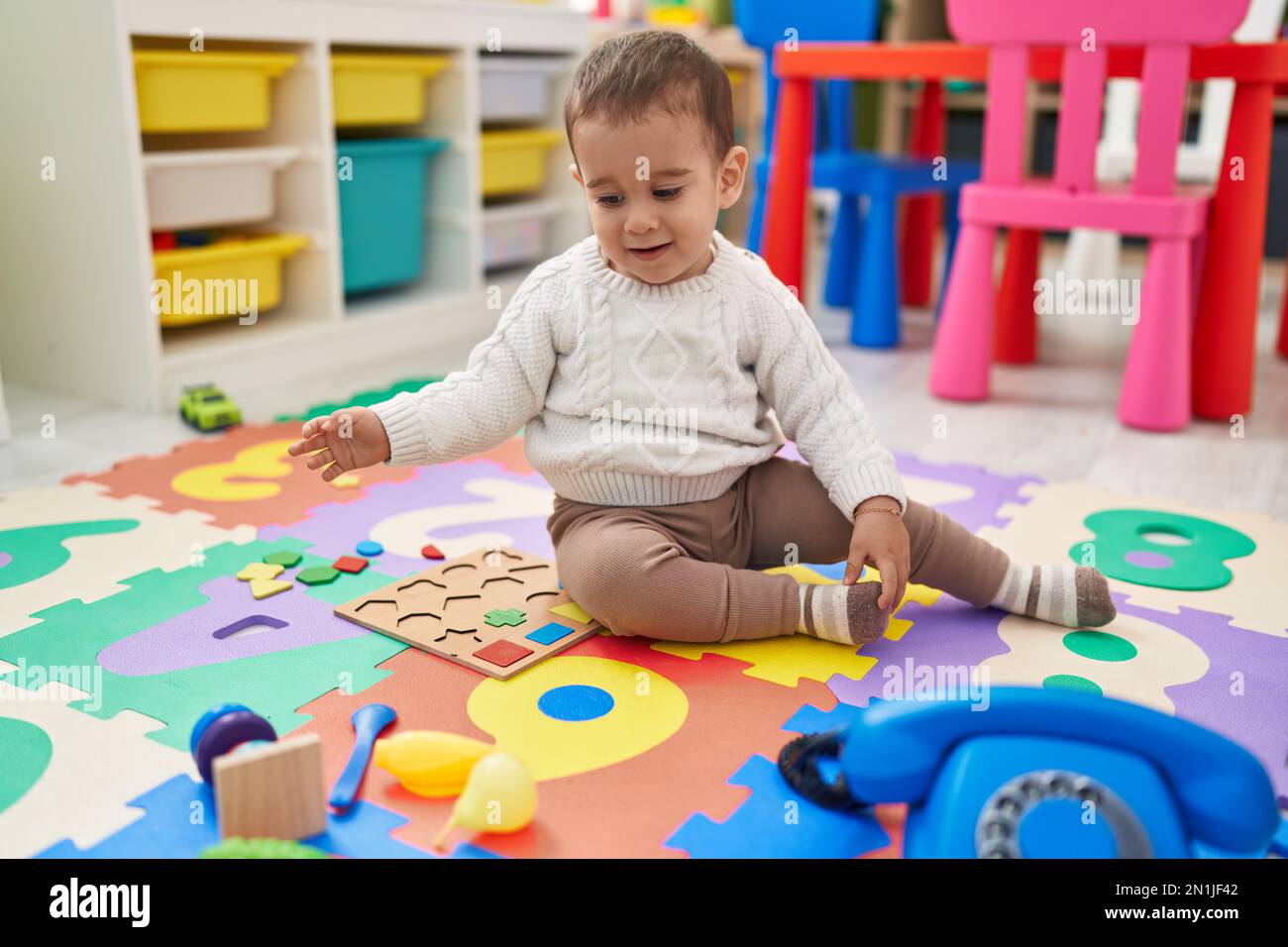 Adorable hispanic toddler smiling confident sitting on floor at ...