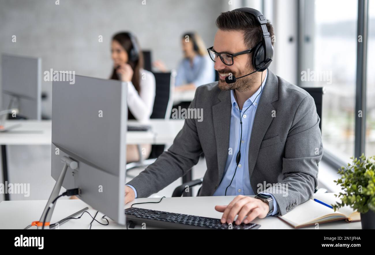 Smiling friendly handsome young male call centre operator working in ...