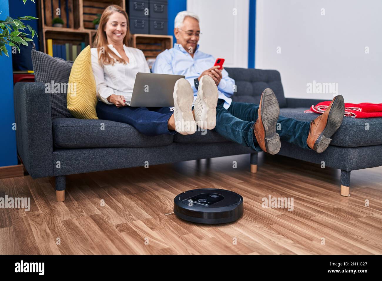 Middle age man and woman couple cleaning floor using robot cleaner at ...