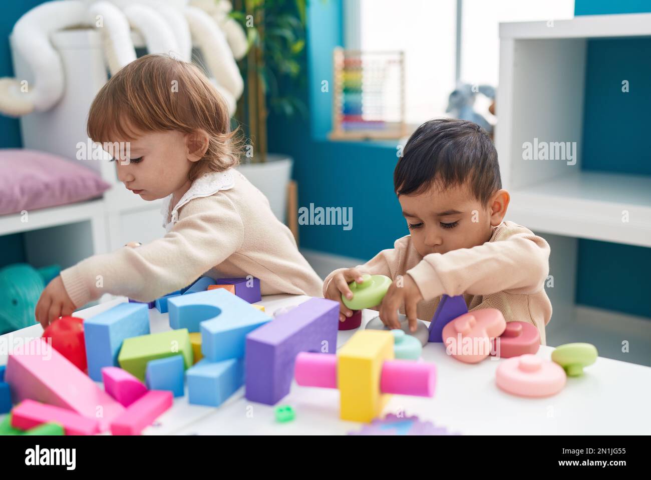 Two kids playing with construction blocks standing at kindergarten ...