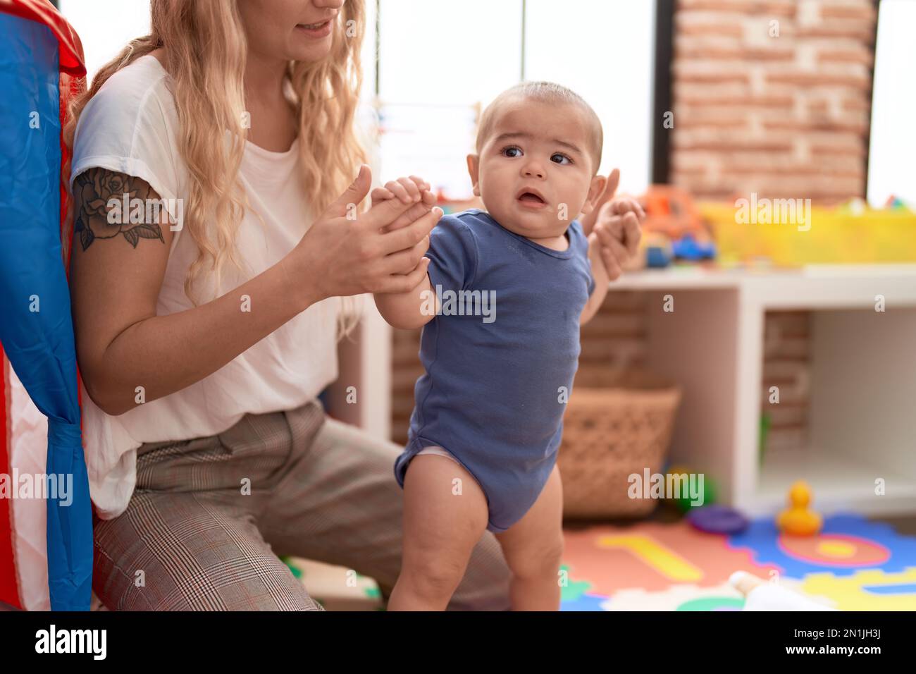 Teacher and preschool student standing with relaxed expression at ...
