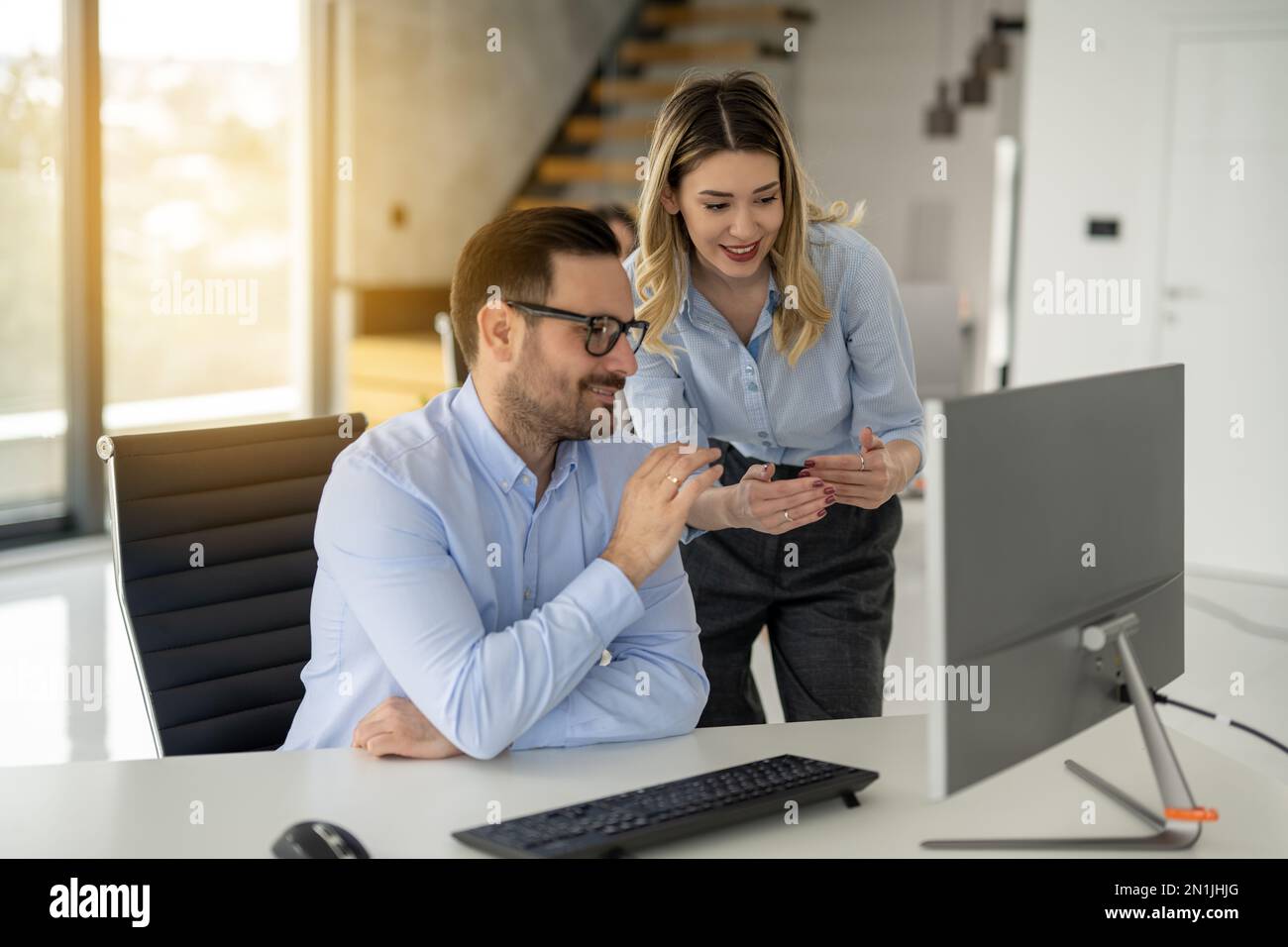 Business woman and man discussing project on desktop computer monitor ...