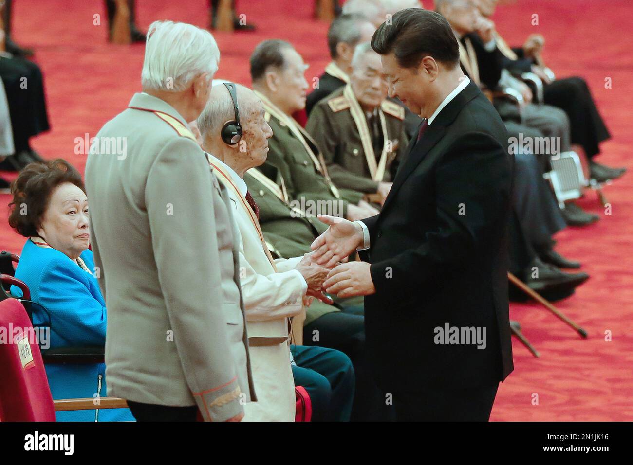 China's President Xi Jinping, center right, shades hand with a veteran ...
