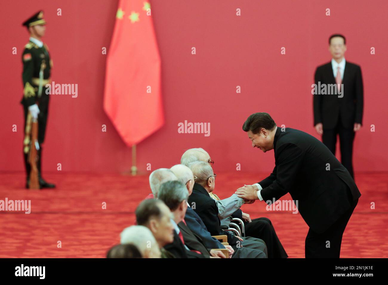 China's President Xi Jinping, right, shades hand with veteran Li Li'an ...