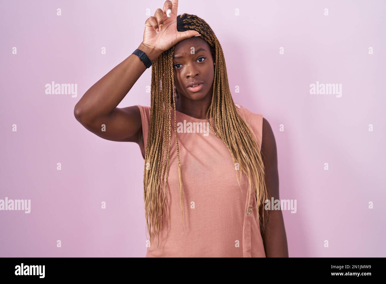 African american woman with braided hair standing over pink background ...