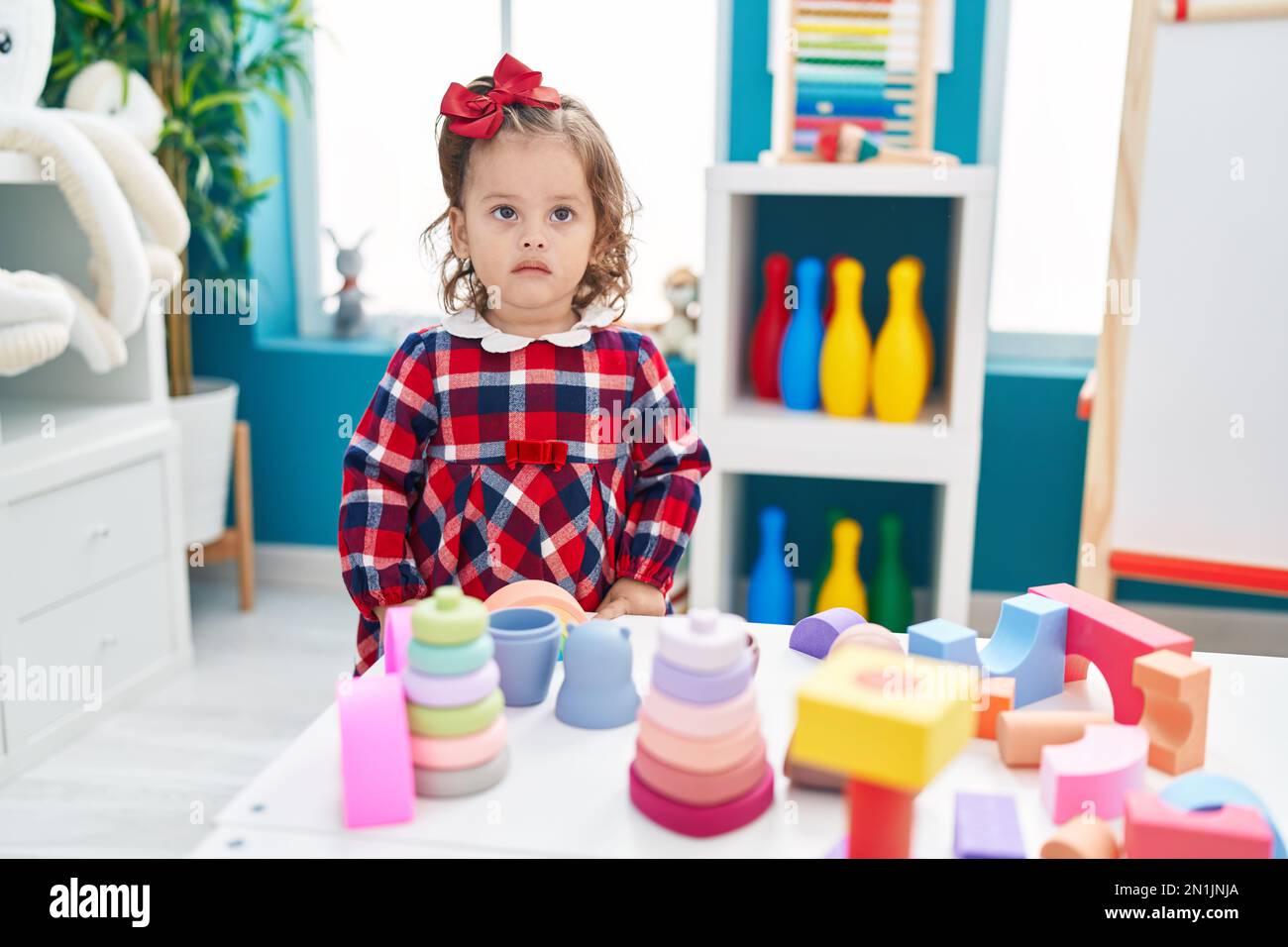 Adorable blonde toddler standing with serious expression at ...