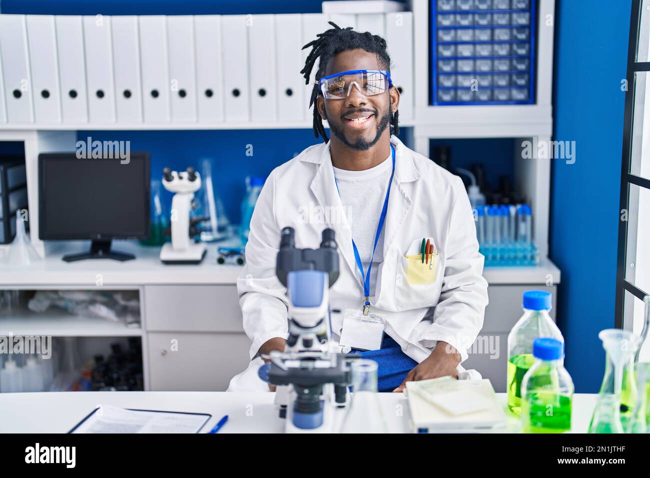 African man with dreadlocks working at scientist laboratory with a ...