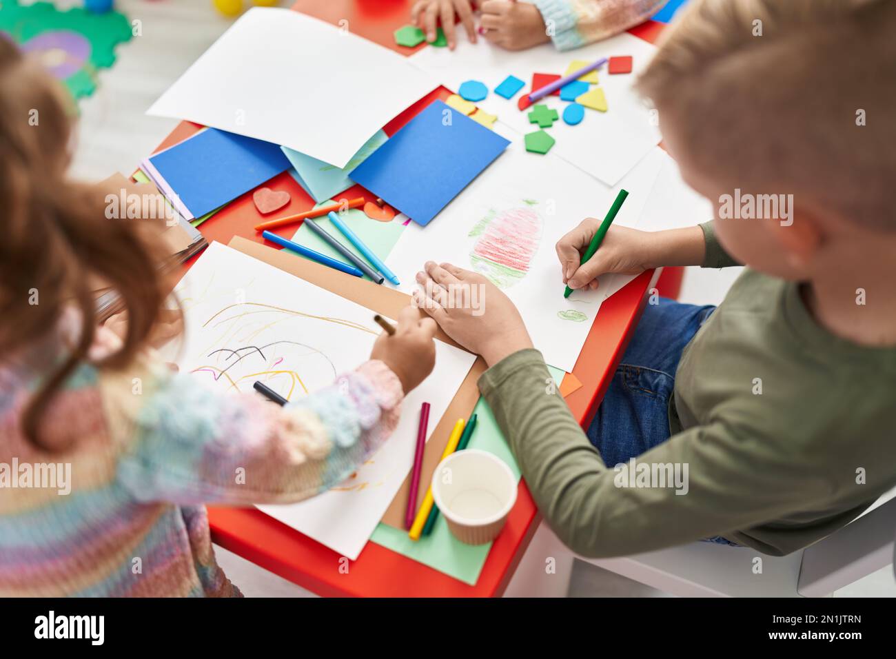 Two kids preschool students sitting on table drawing on paper at ...
