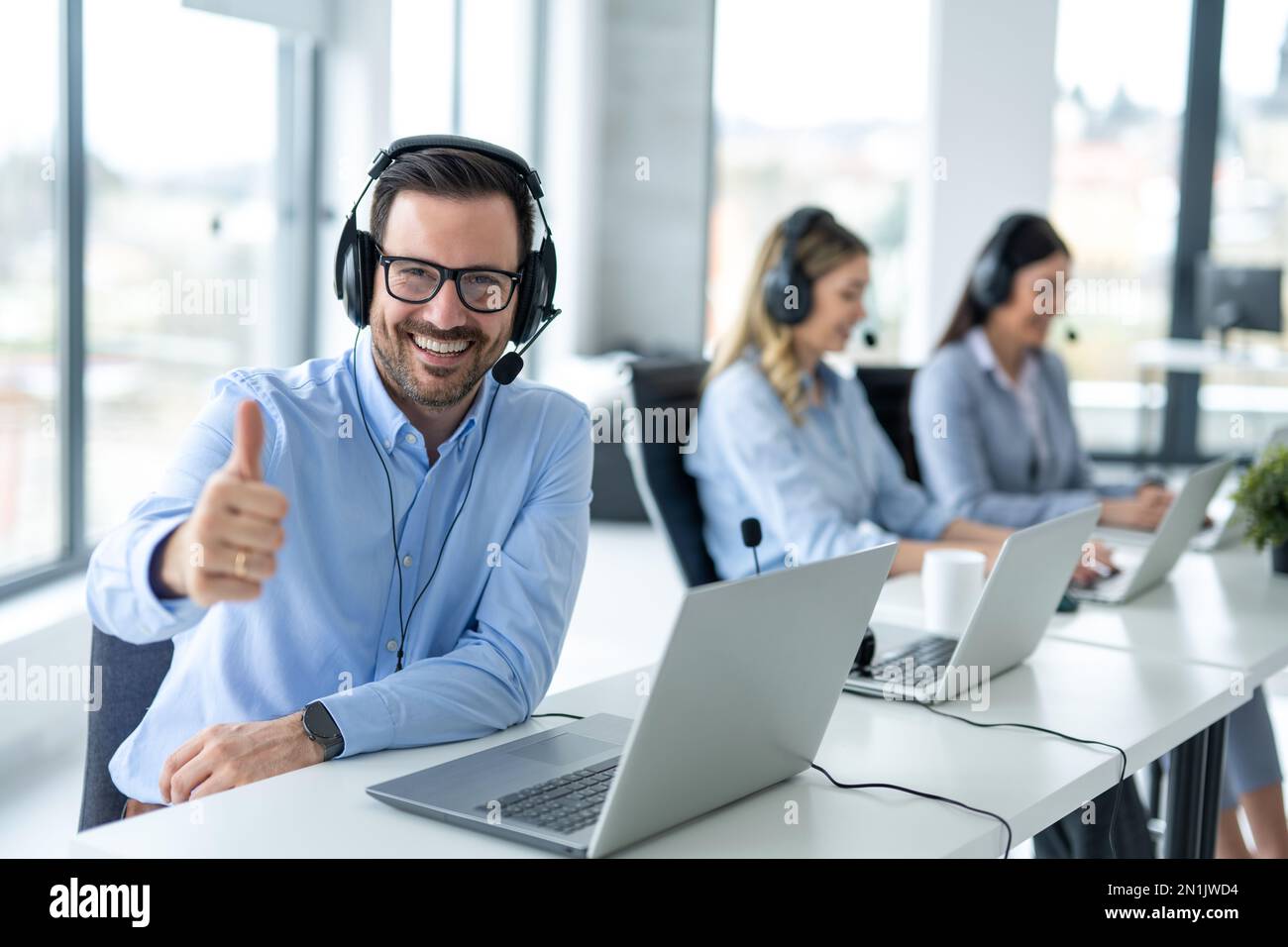 Handsome male online support agent with headset showing thumb up ...