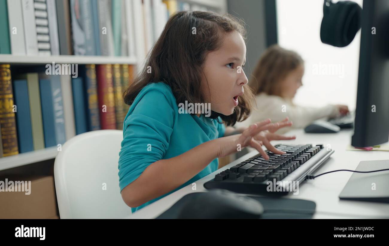 Two kids students using computer studying at classroom Stock Photo - Alamy
