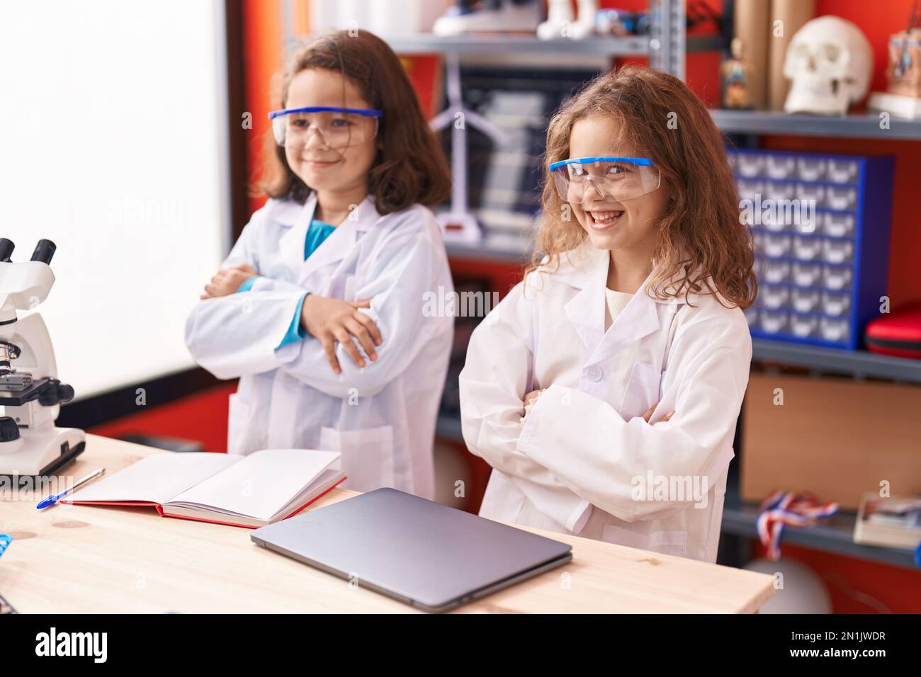 Two kids students standing with arms crossed gesture at laboratory ...