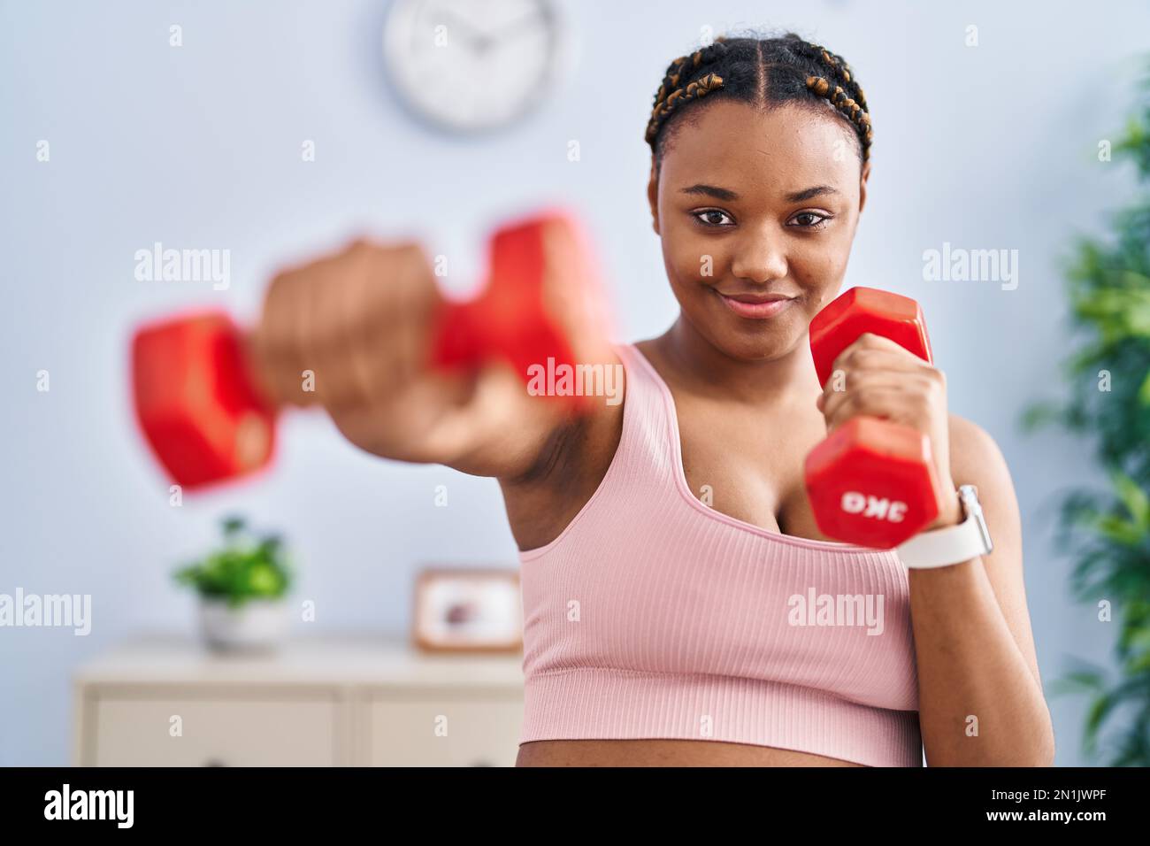 African american woman using dumbbells boxing at home Stock Photo - Alamy