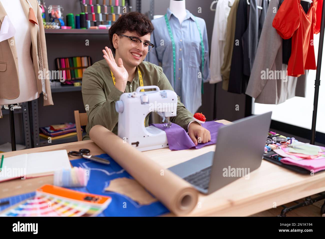 Young non binary man dressmaker designer on video call with laptop ...