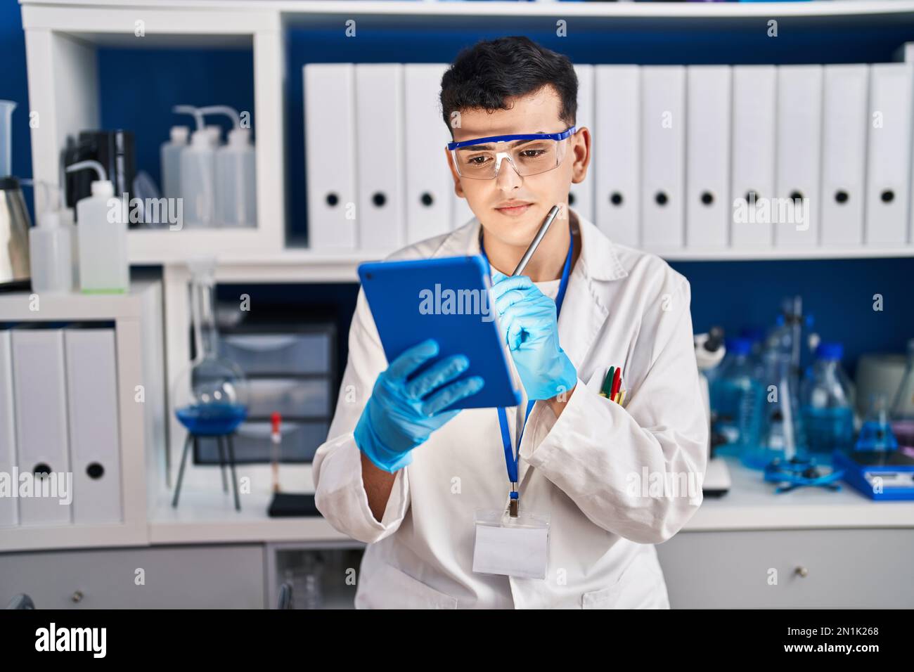 Young non binary man scientist write on touchpad at laboratory Stock Photo - Alamy