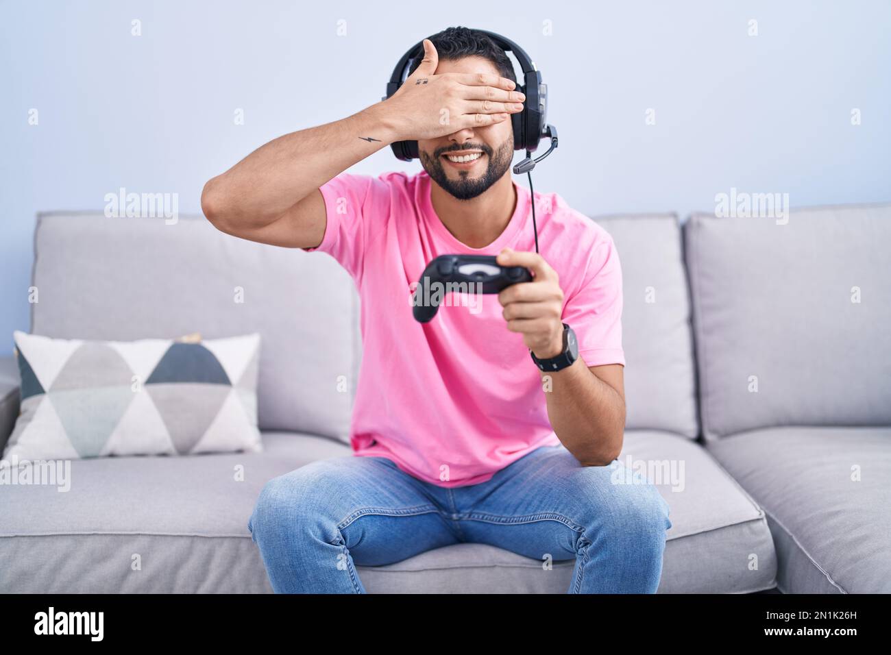 Hispanic young man playing video game holding controller sitting on the ...