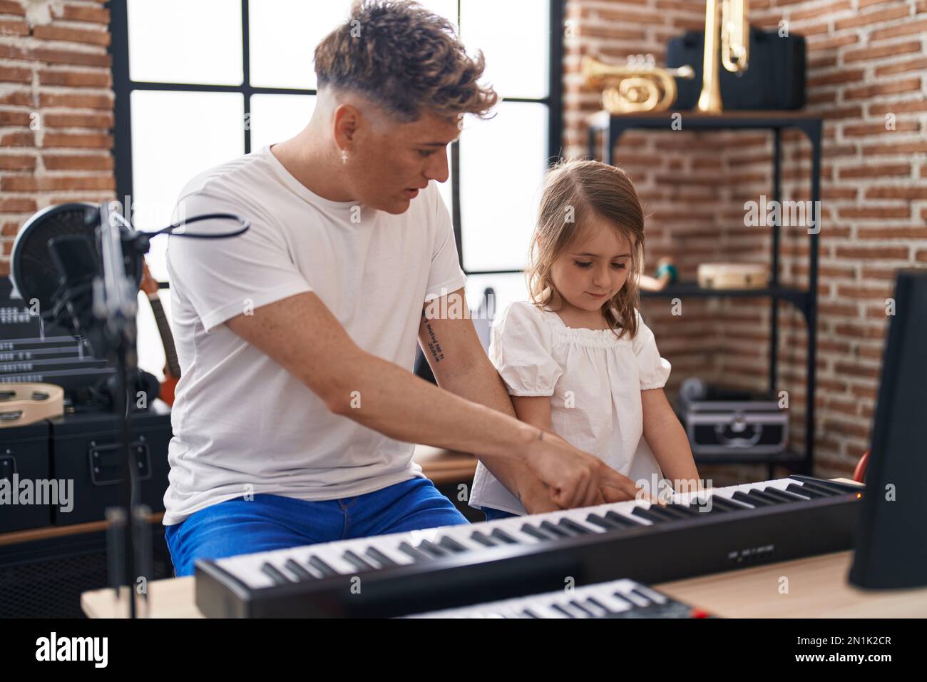 Father and daughter playing piano keyboard at music studio Stock Photo ...