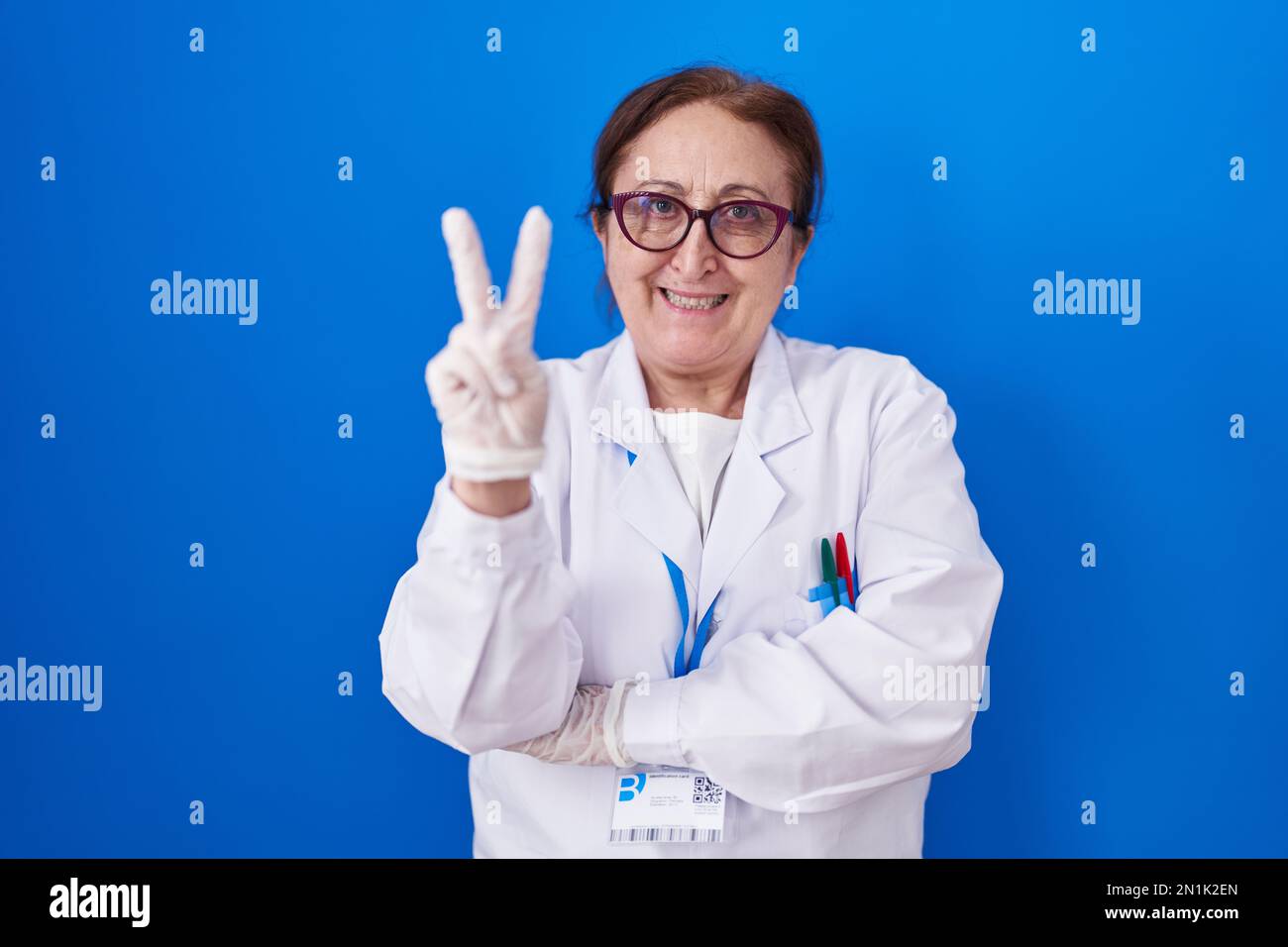 Senior woman with glasses wearing scientist uniform smiling with happy ...