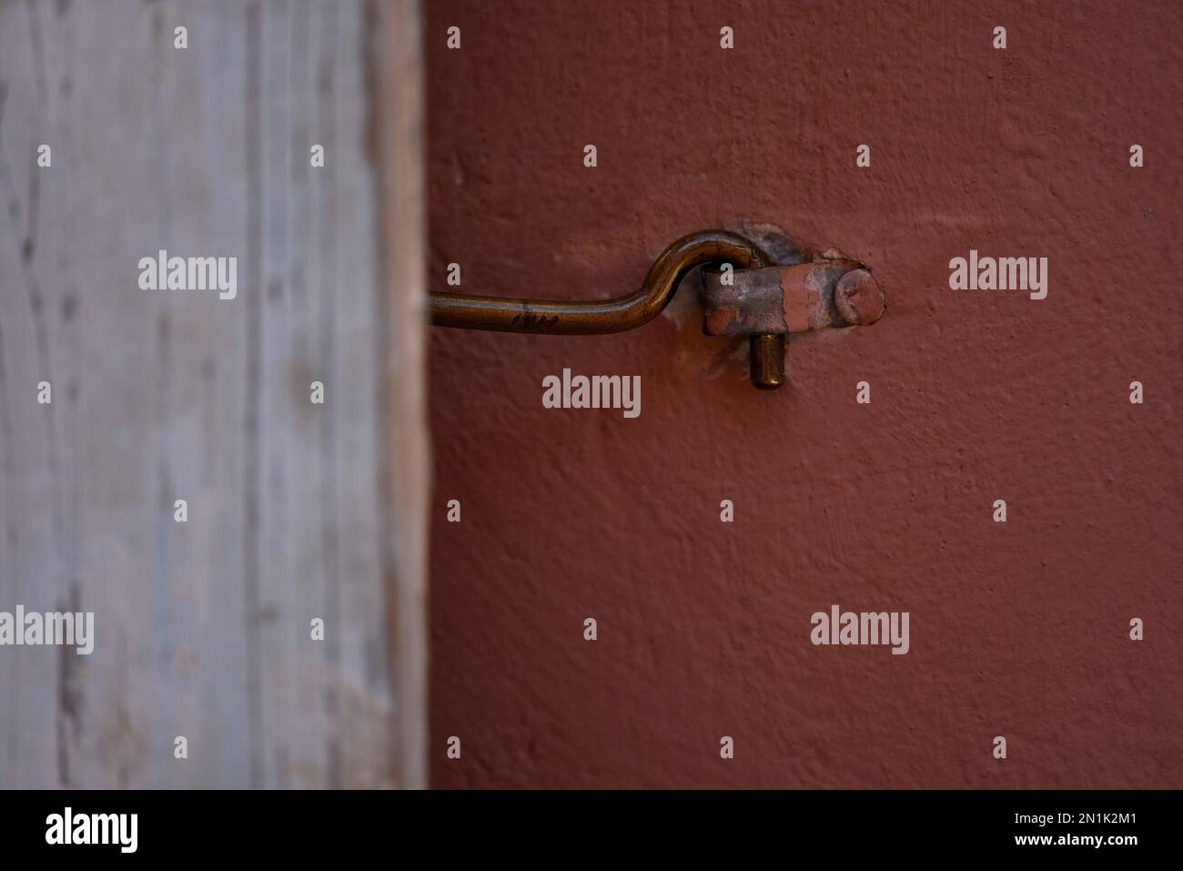 Antique wooden door metal latch on a Venetian red stucco wall Stock ...