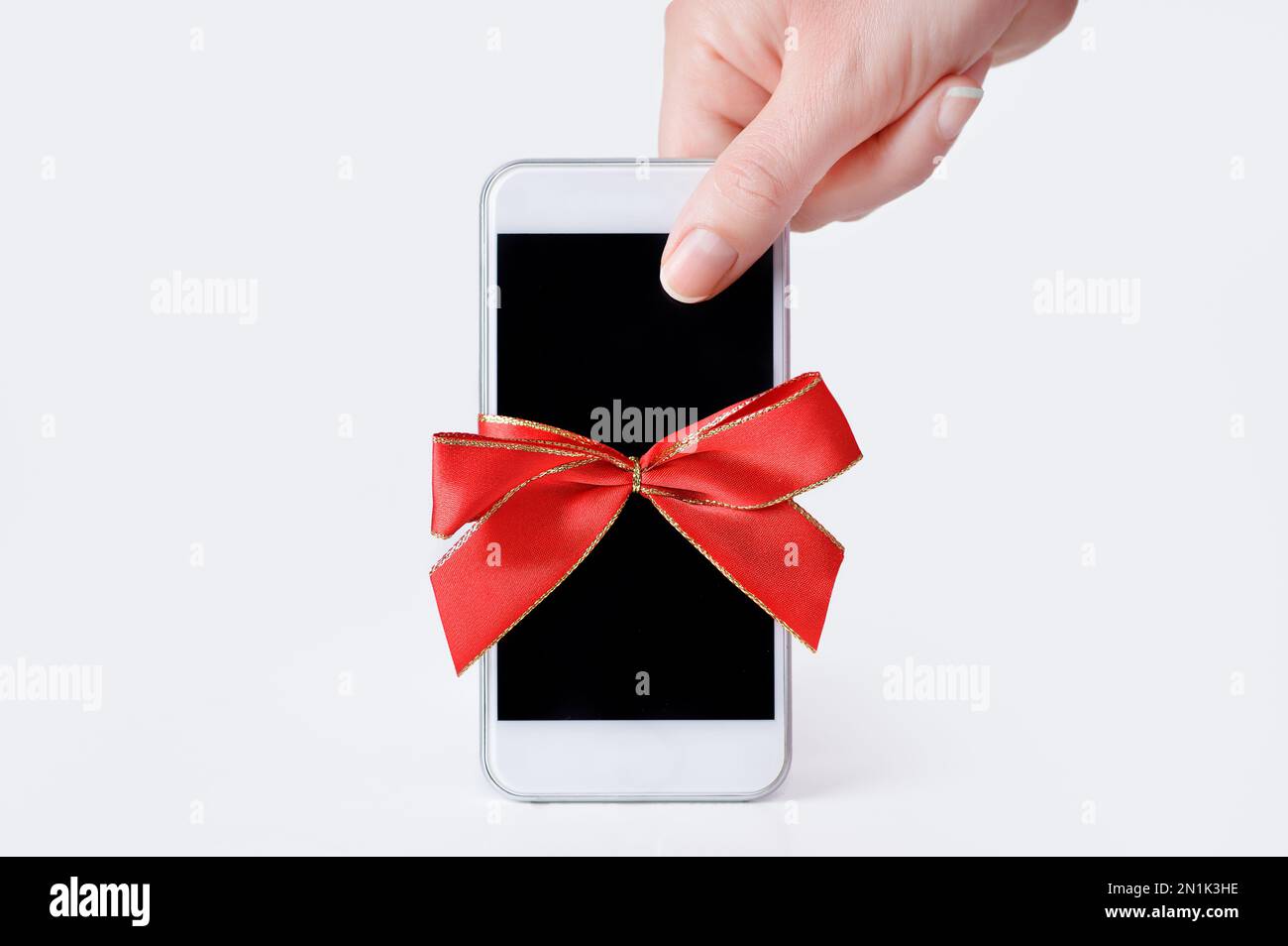 hand holding a phone gift with a red ribbon and white background Stock ...