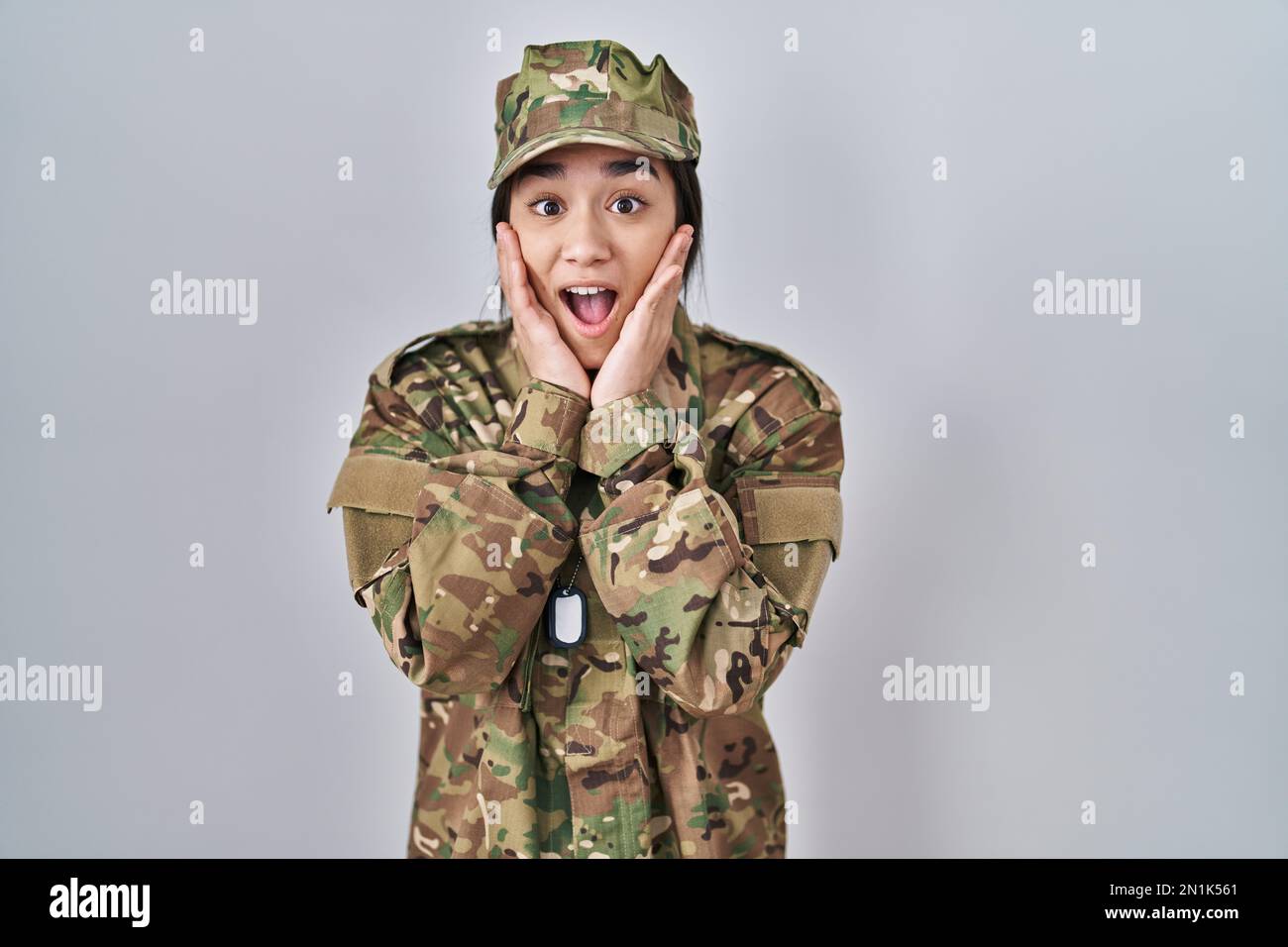 Young south asian woman wearing camouflage army uniform afraid and ...