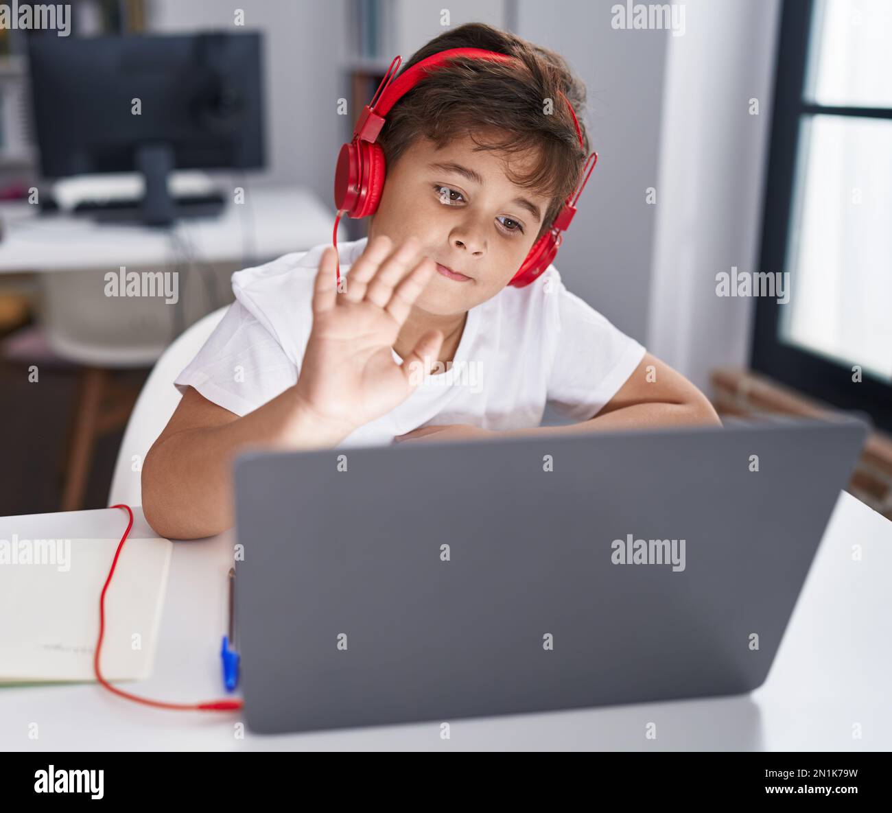 Adorable hispanic boy student using computer having long distance ...