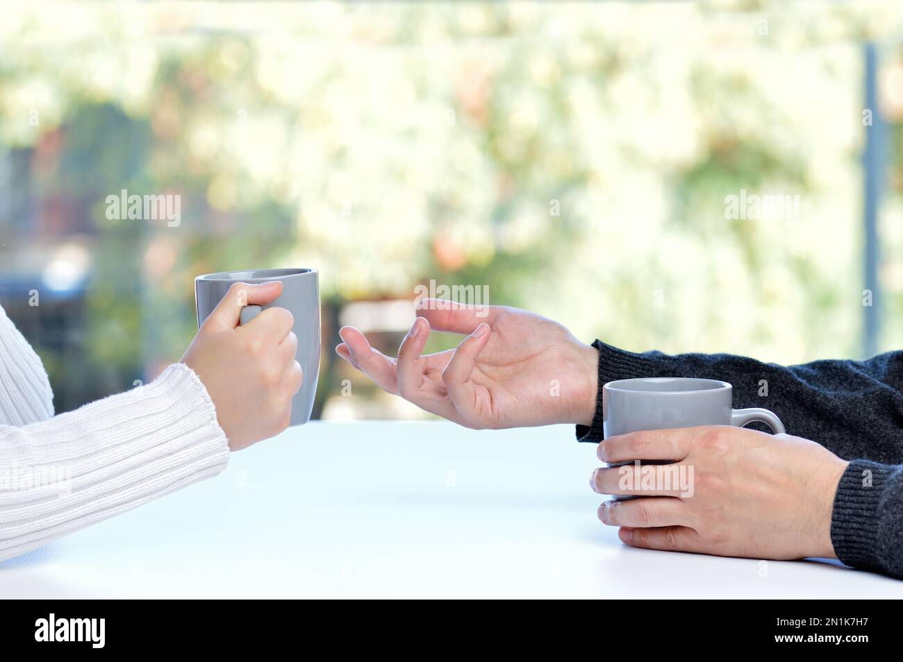 Two women hands talking in a bar holding coffee cups Stock Photo - Alamy