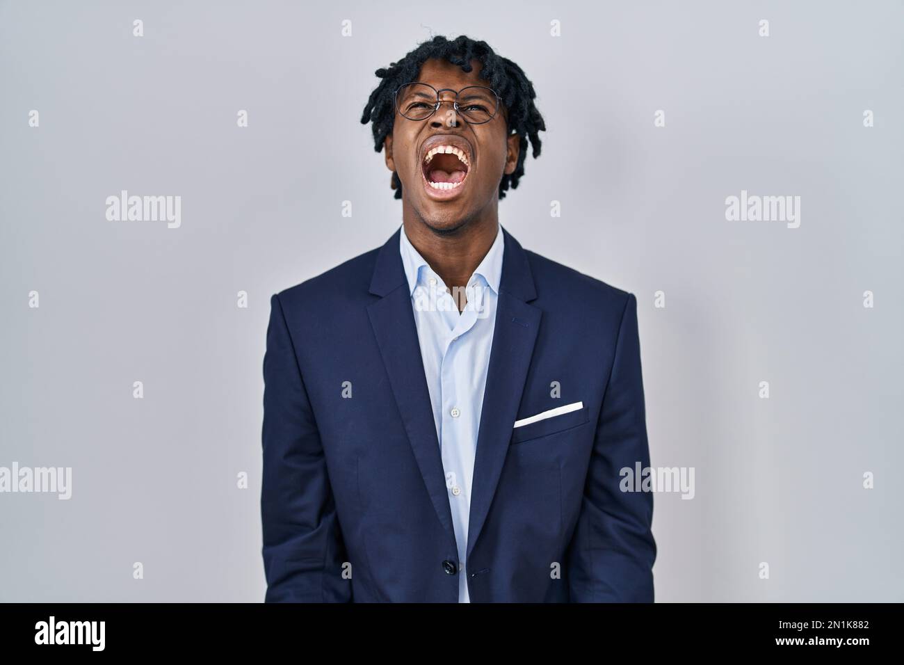 Young african man with dreadlocks wearing business jacket over white ...