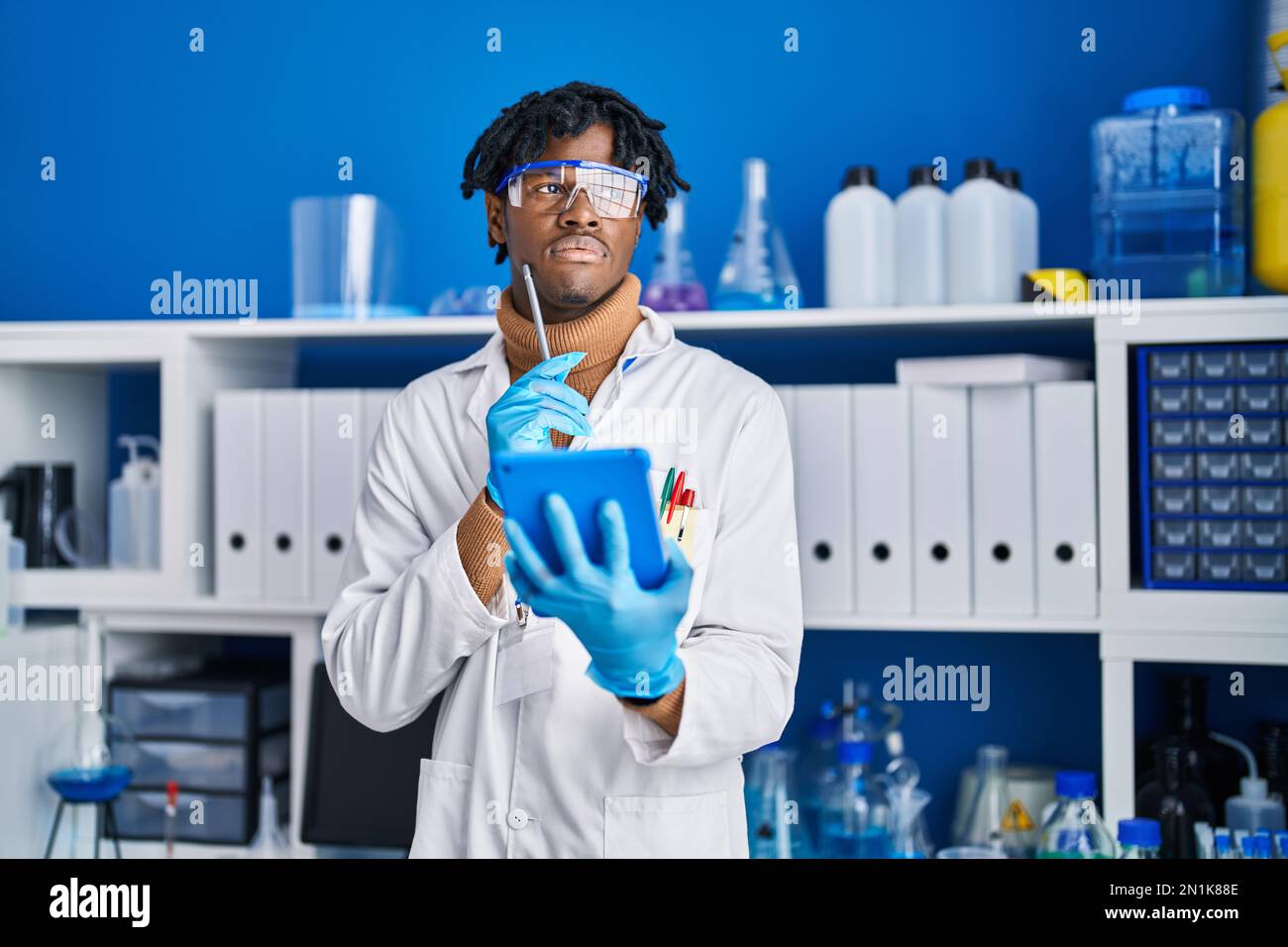 African american man scientist using touchpad at laboratory Stock Photo - Alamy