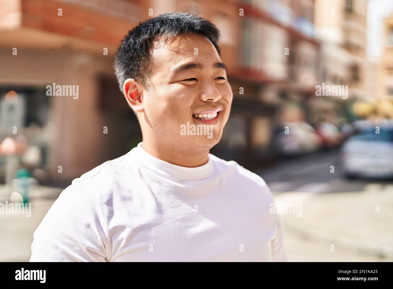 Young chinese man smiling confident standing at street Stock Photo - Alamy