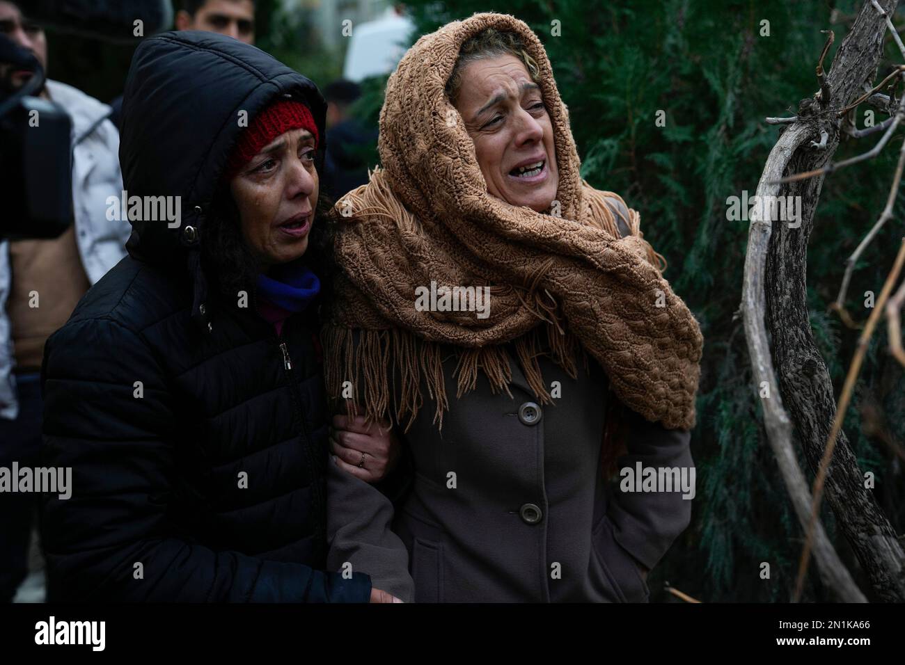 Women cry as they watch while the emergency teams search for people in ...