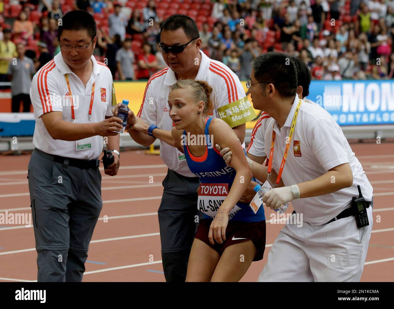 Palestinian Mayada Al-Sayed is assisted by officials after she ...