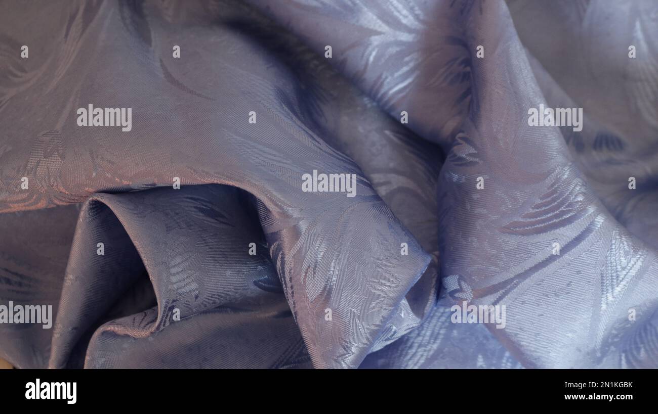curved in smooth waves blue shiny textile material of silver-blue color ...
