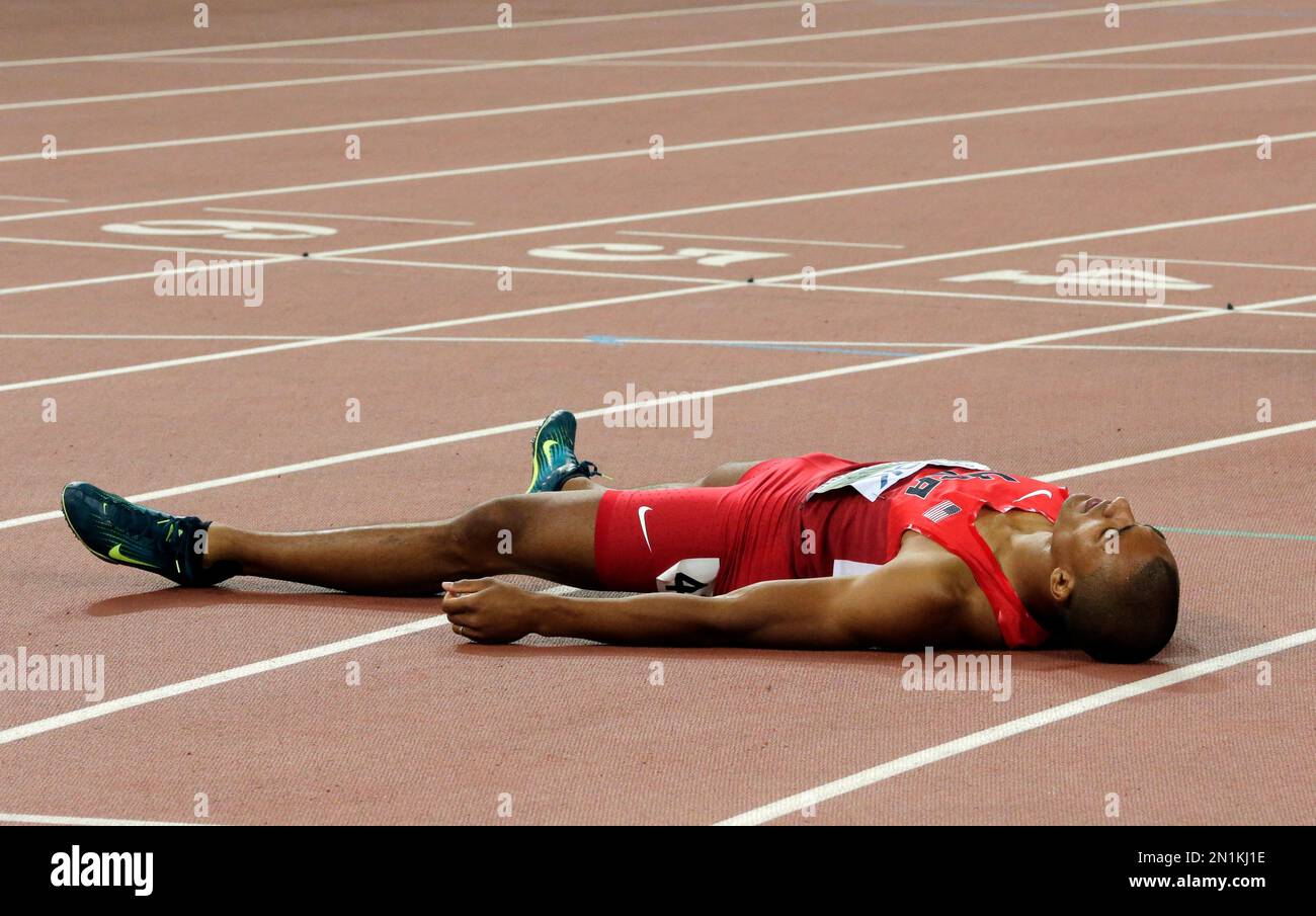 United States' Ashton Eaton lays on the track after crossing the line ...