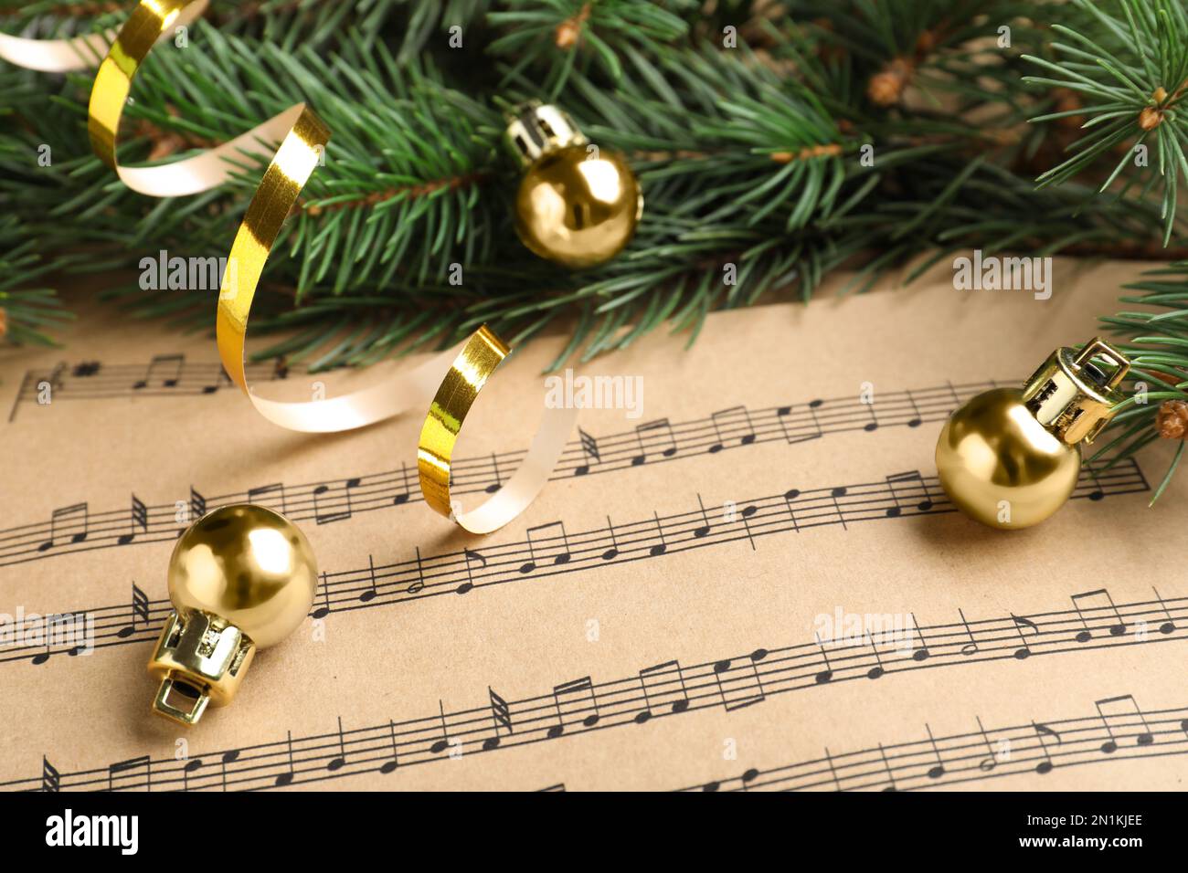 Fir branches, golden streamer and balls on Christmas music sheets ...