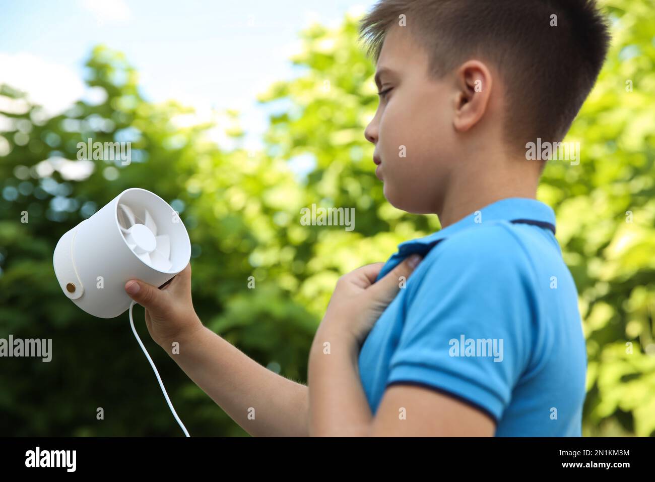 Little boy with portable fan outdoors. Summer heat Stock Photo - Alamy
