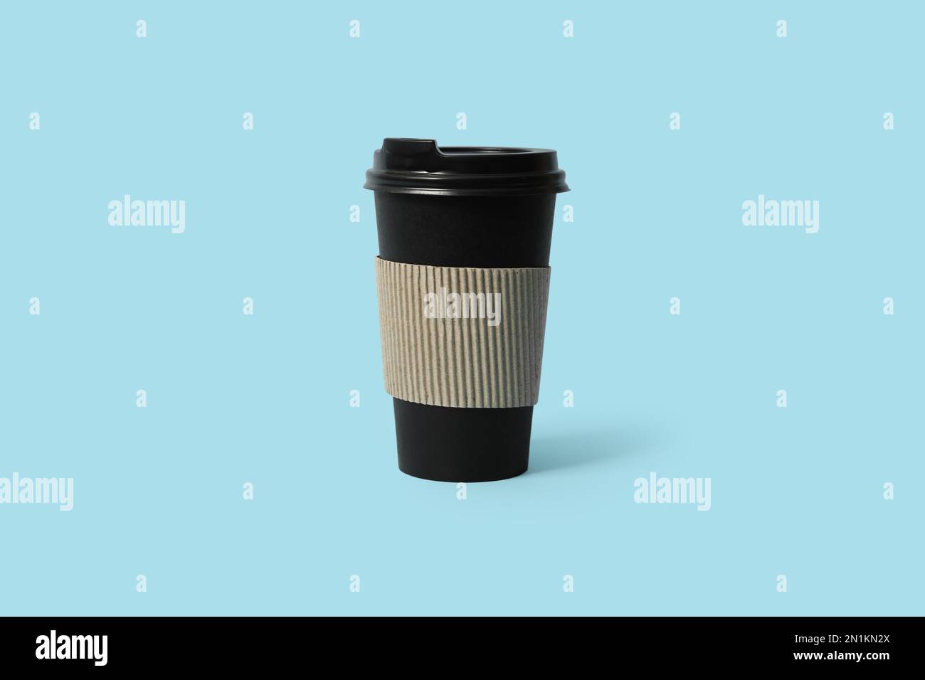 Takeaway paper coffee cup with cardboard sleeve on light blue ...