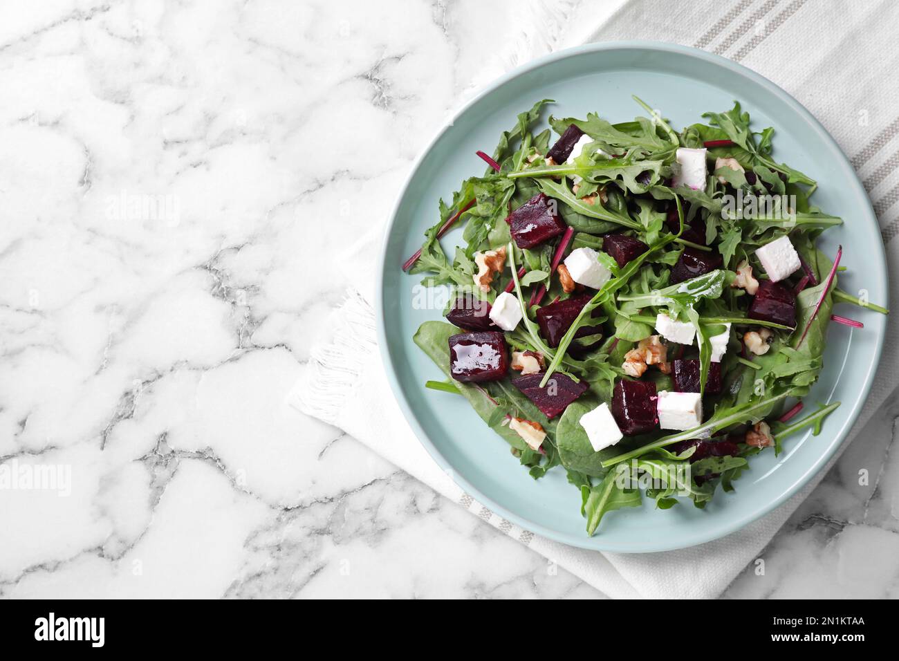 Fresh delicious beet salad on white marble table, top view. Space for ...