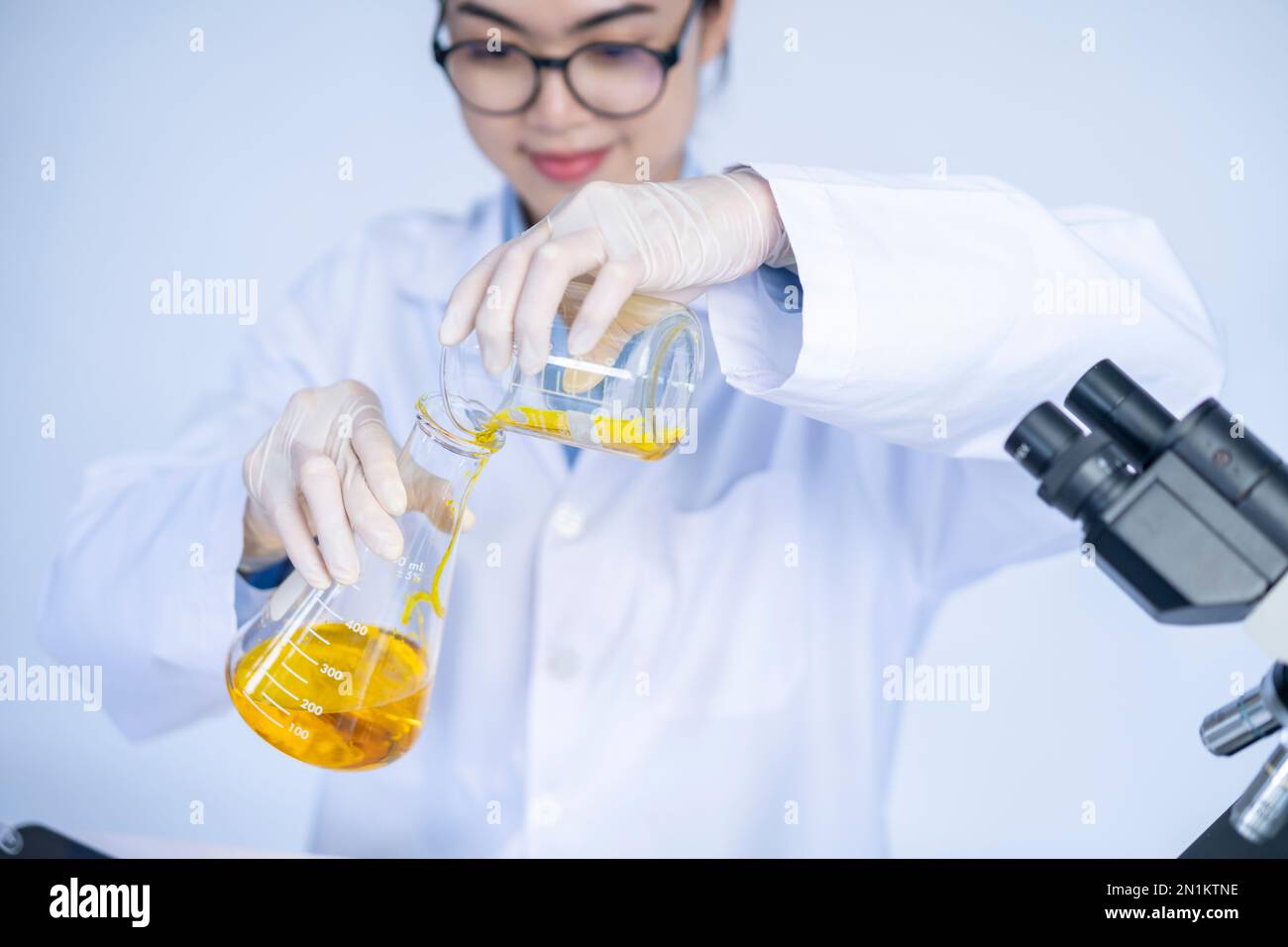 laboratory researcher holding medical glass bottle with yellow liquid ...