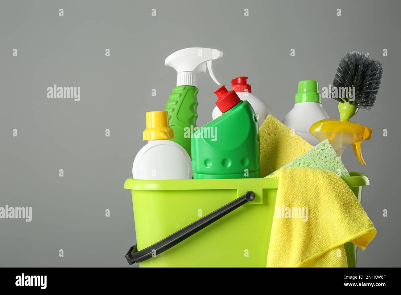 Bucket with cleaning products and tools on grey background, closeup ...