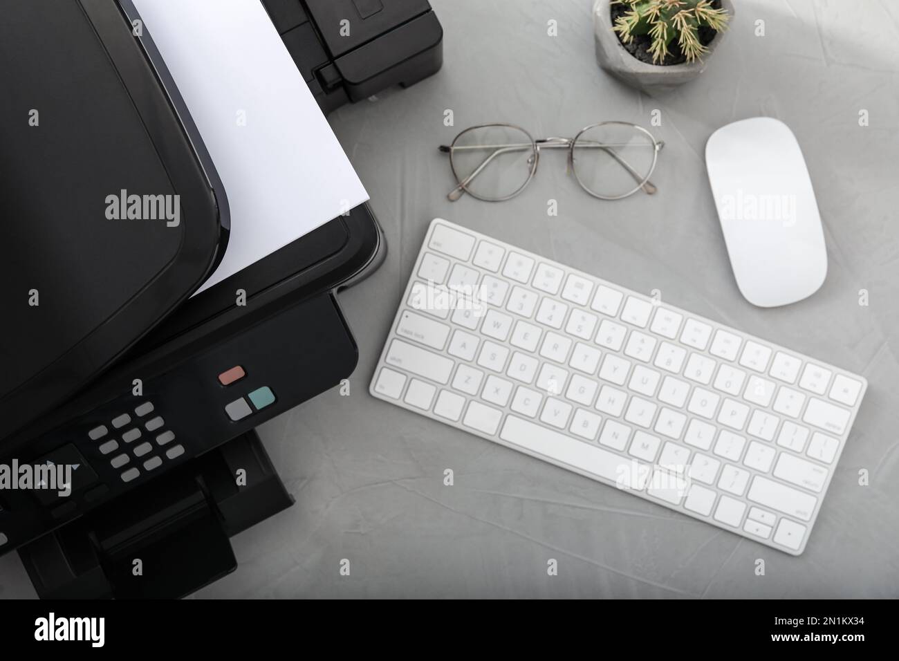 Modern printer, computer keyboard and mouse on grey table, flat lay ...
